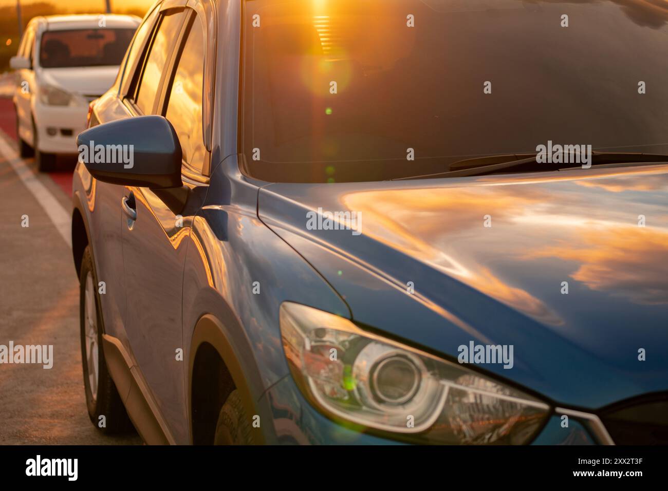 Luxury SUV with modern design parked on roadside at sunset. Front view ...
