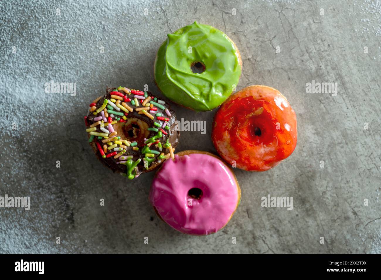 Four mini donuts with different colors and sprinkles on top. The mini ...
