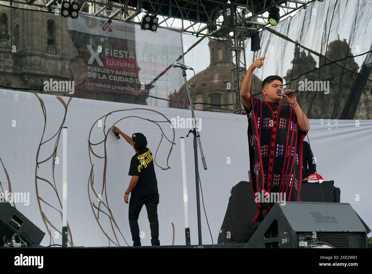 Mexican-Triqui artist Carlos CGH, wearing a black and red “gabán,” a ...