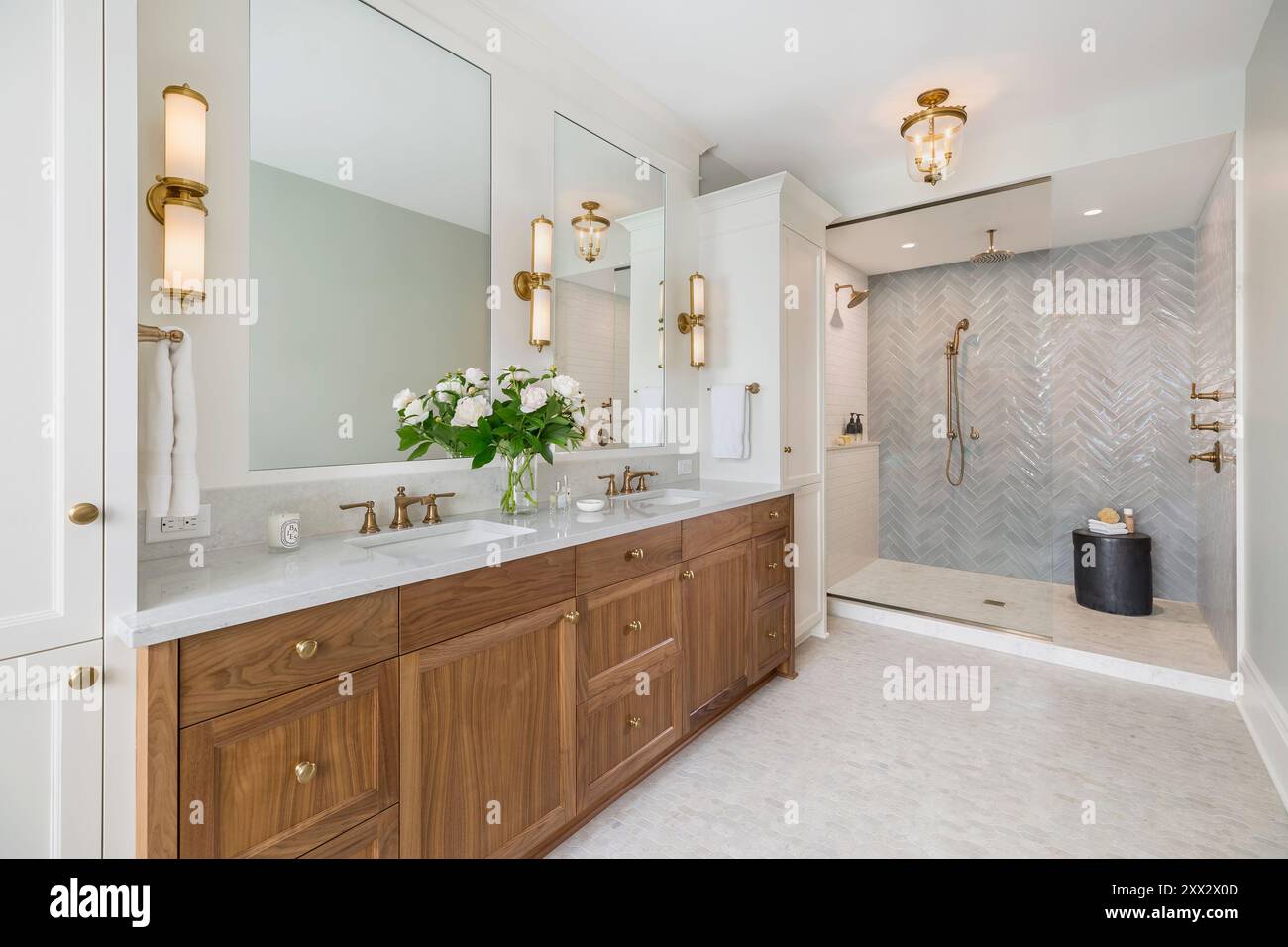 White bathroom with long walnut vanity and walk-in shower Stock Photo ...