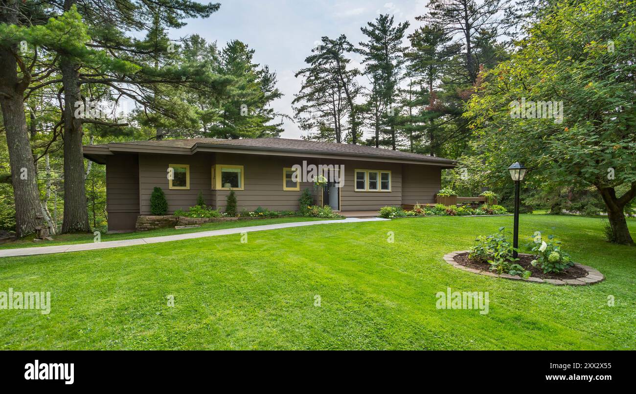 Front exterior of rambler house surrounded by greenery Stock Photo - Alamy