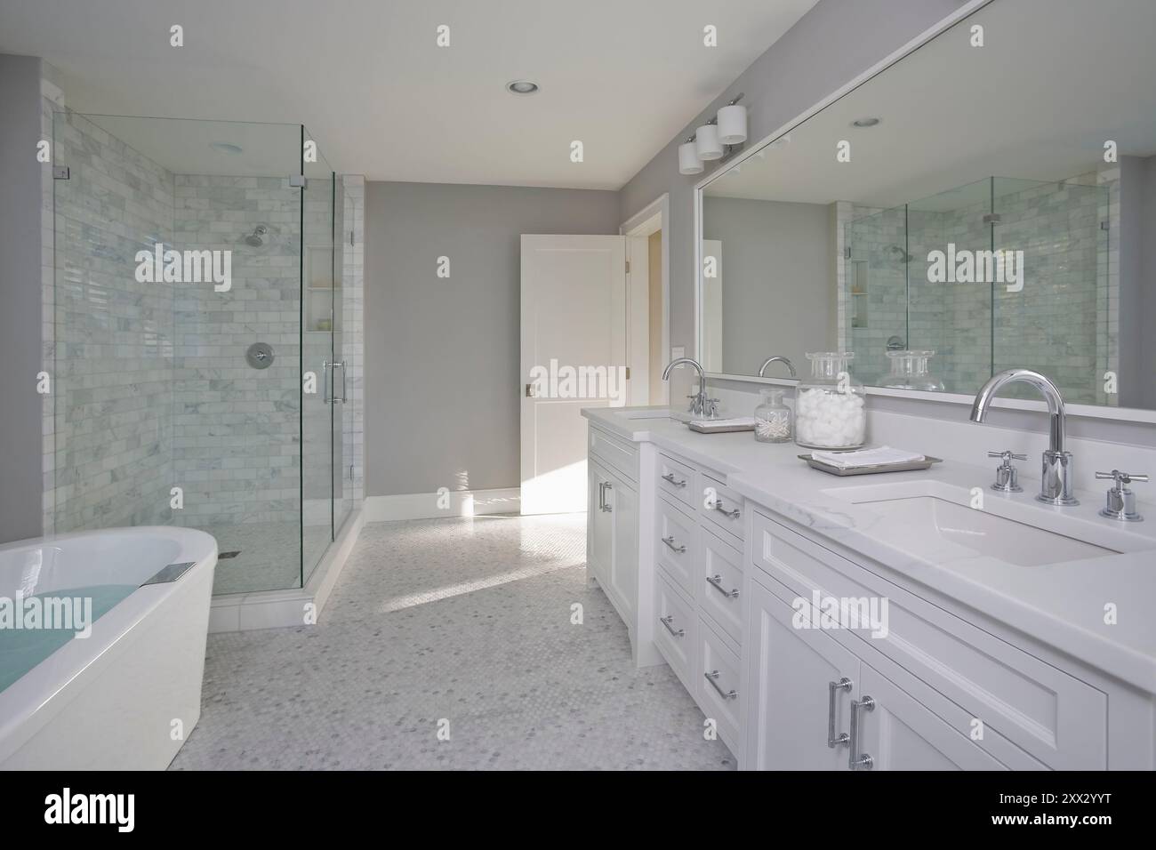 Sleek white bathroom with round tub and walk-in shower Stock Photo - Alamy