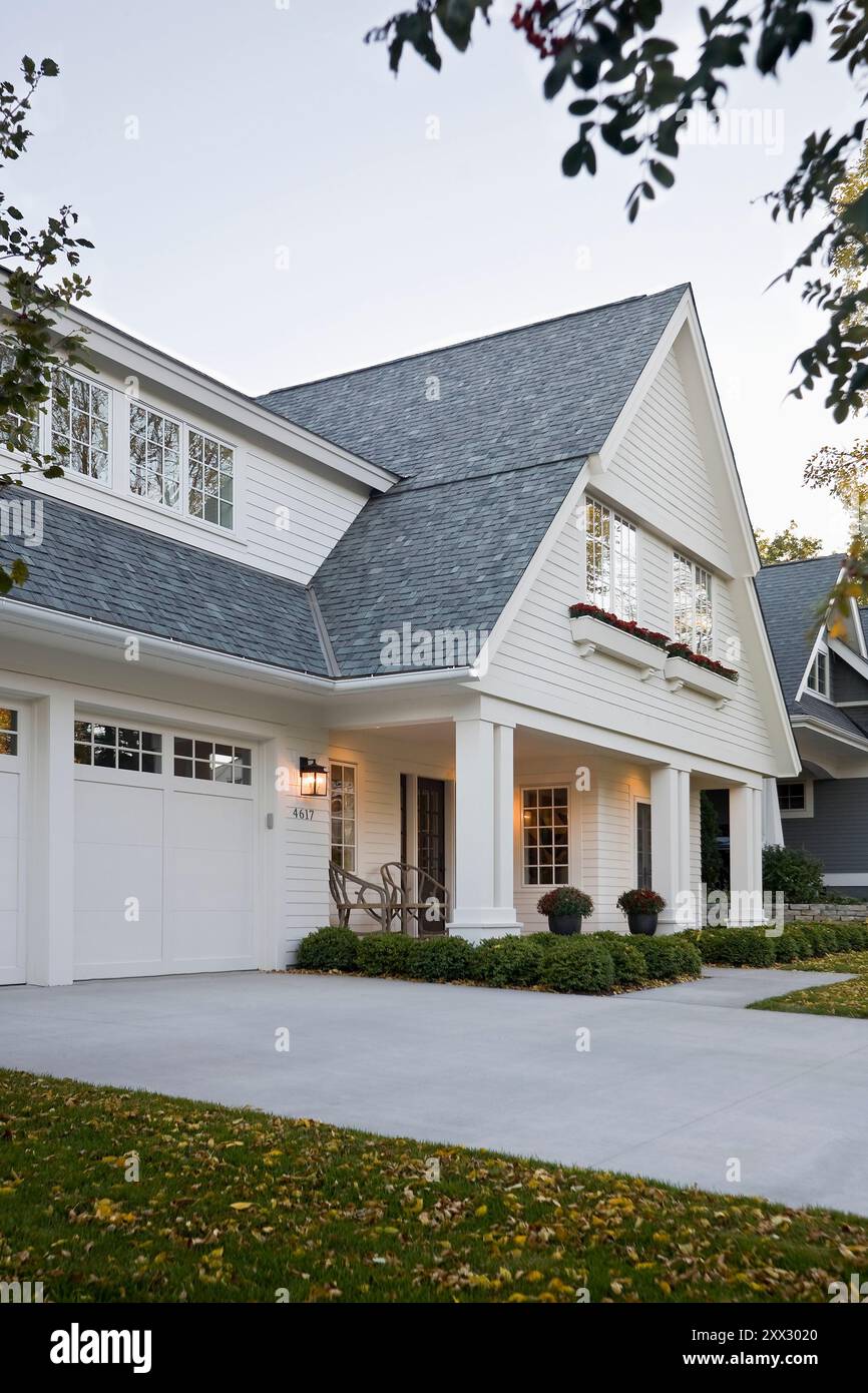 White clapboard house with large front dormer and pillars in front ...