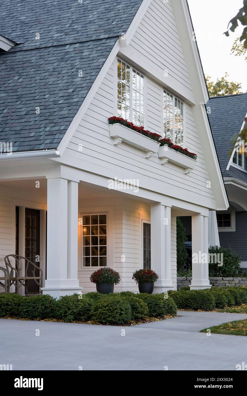 Large A-frame front dormer and pillars of white clapboard house Stock ...