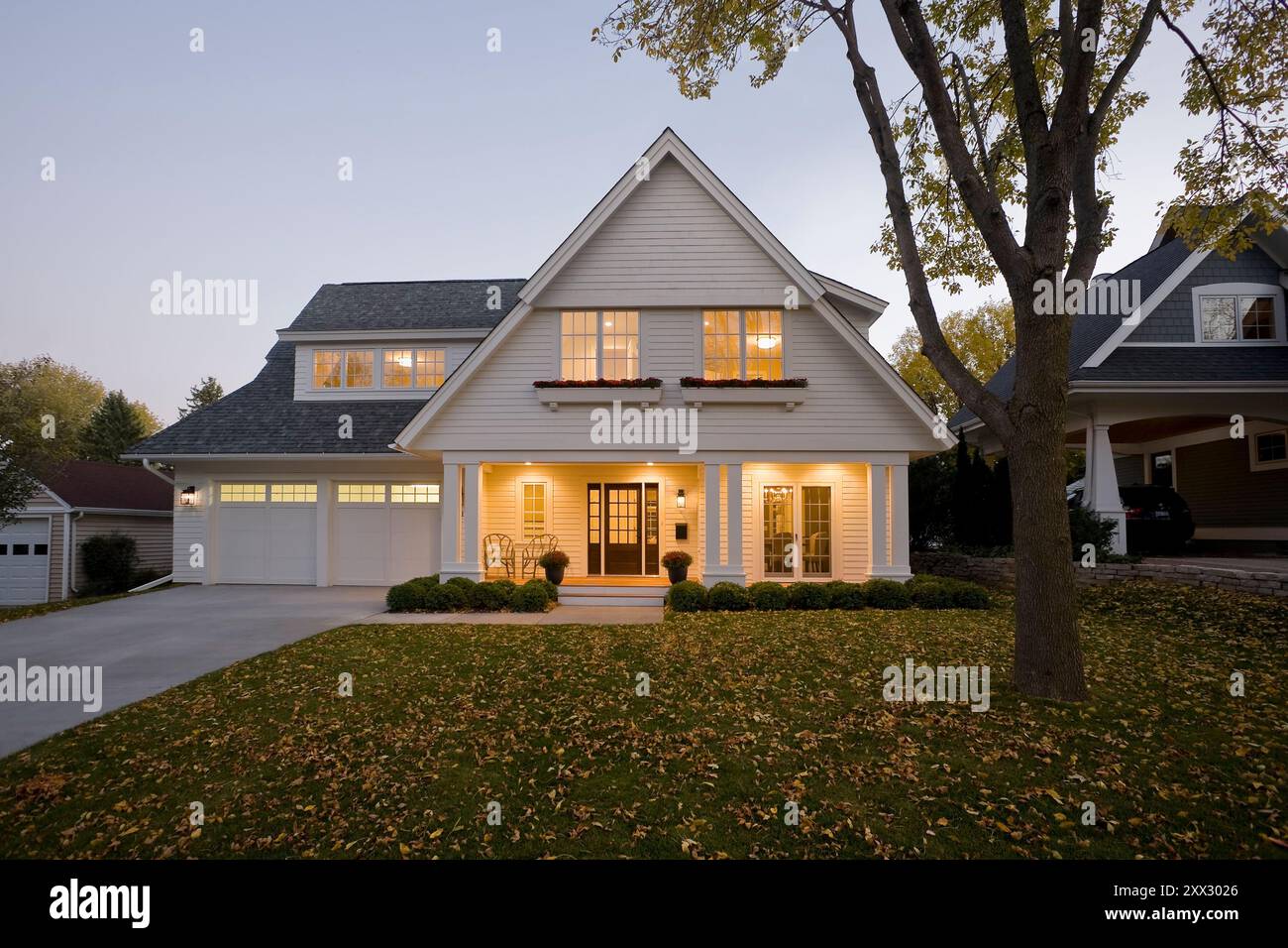 White clapboard house with large front dormer and pillars in front ...