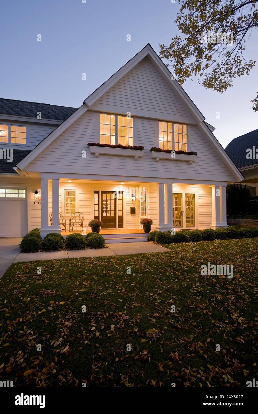 White clapboard house with large front dormer and pillars in front ...