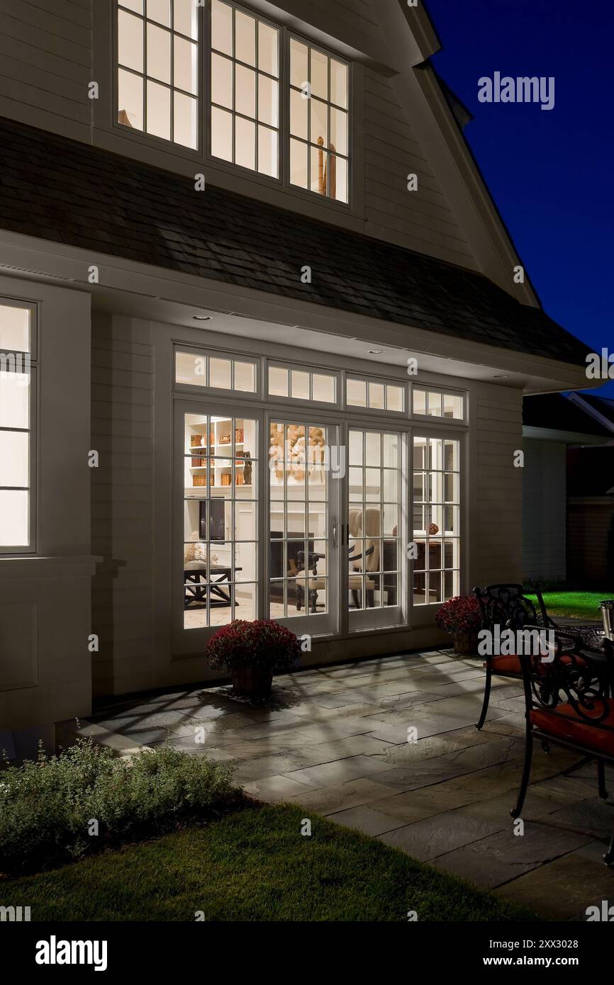 Back of house at night showing patio and view into living room Stock ...