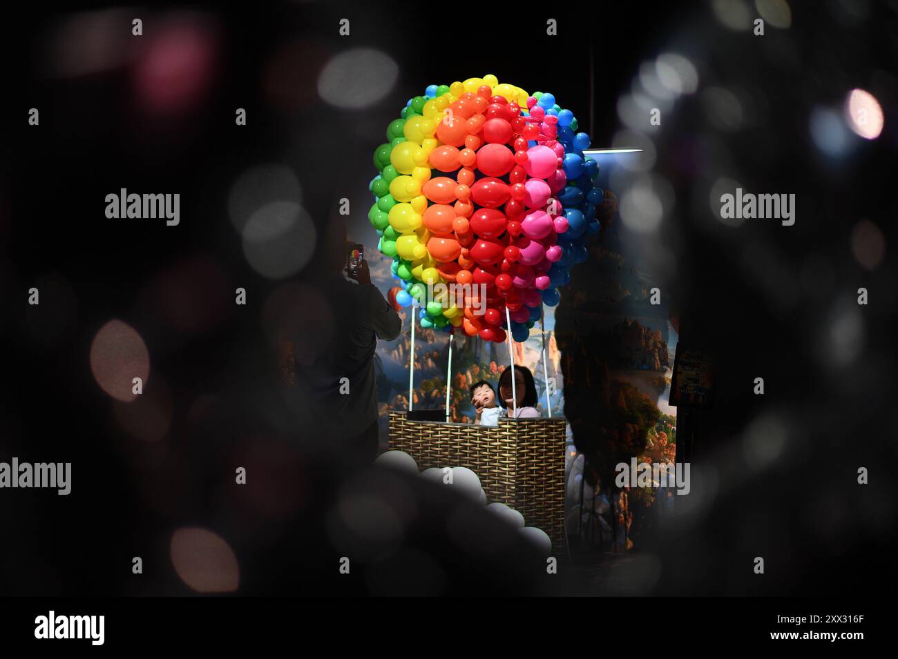 New York, USA. 21st Aug, 2024. People pose in a balloon basket made of ...