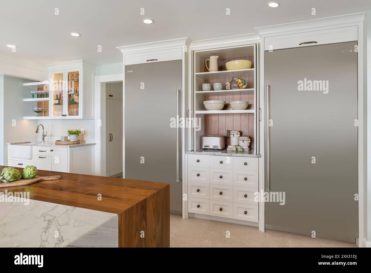 Corner of kitchen with Sub-Zero column fridge and freezer and small bar ...