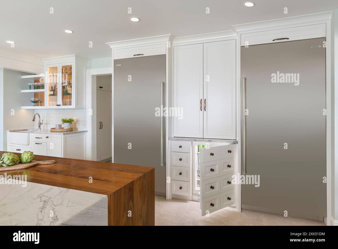 Corner of kitchen with Sub-Zero column fridge and freezer and small bar ...