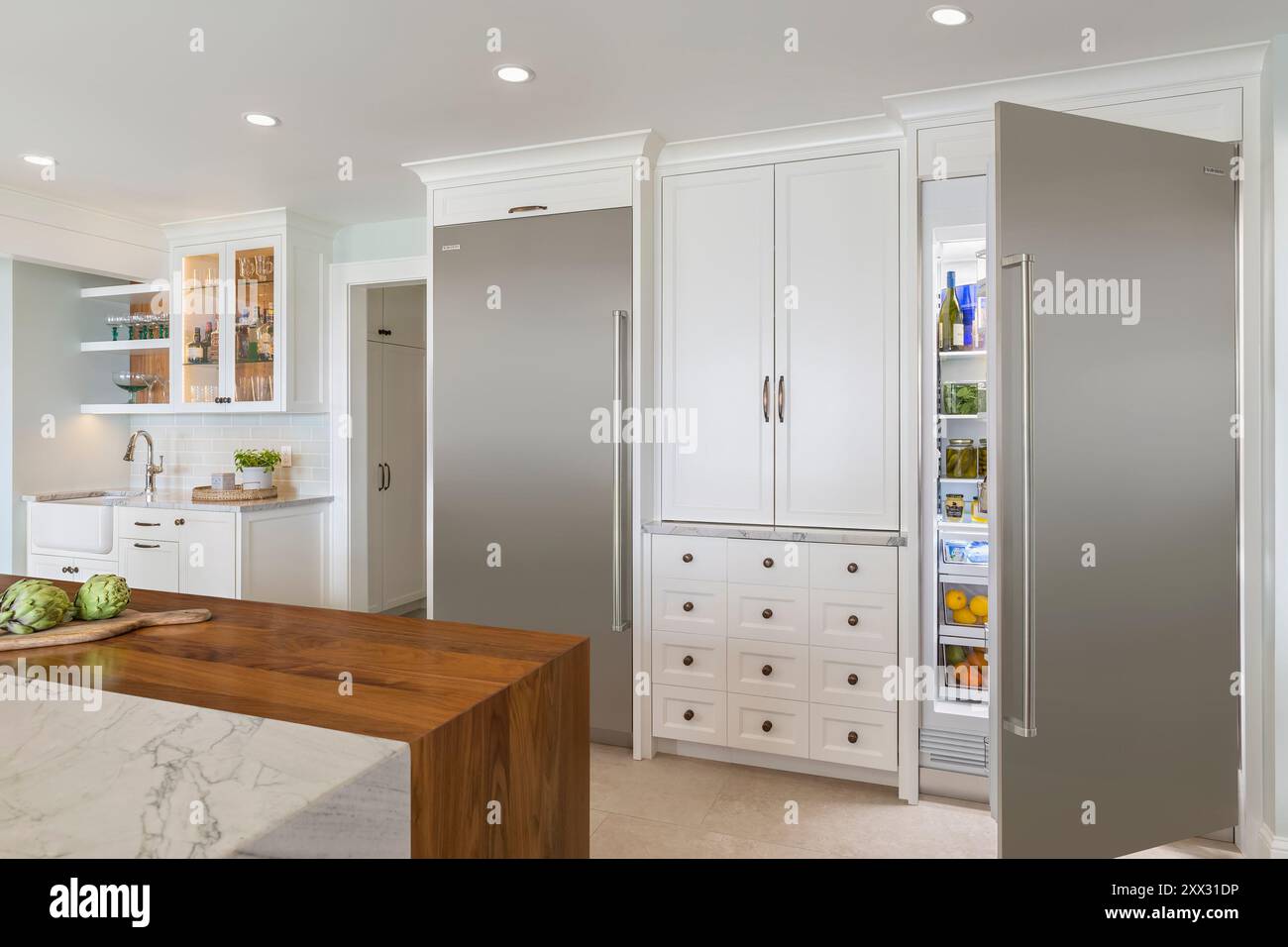 Corner of kitchen with Sub-Zero column fridge and freezer and small bar ...