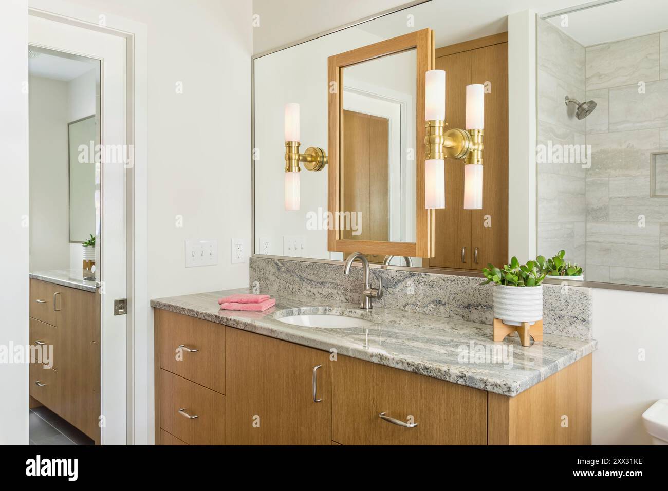 A new bathroom with modern vertical grain oak vanity and mirrored ...