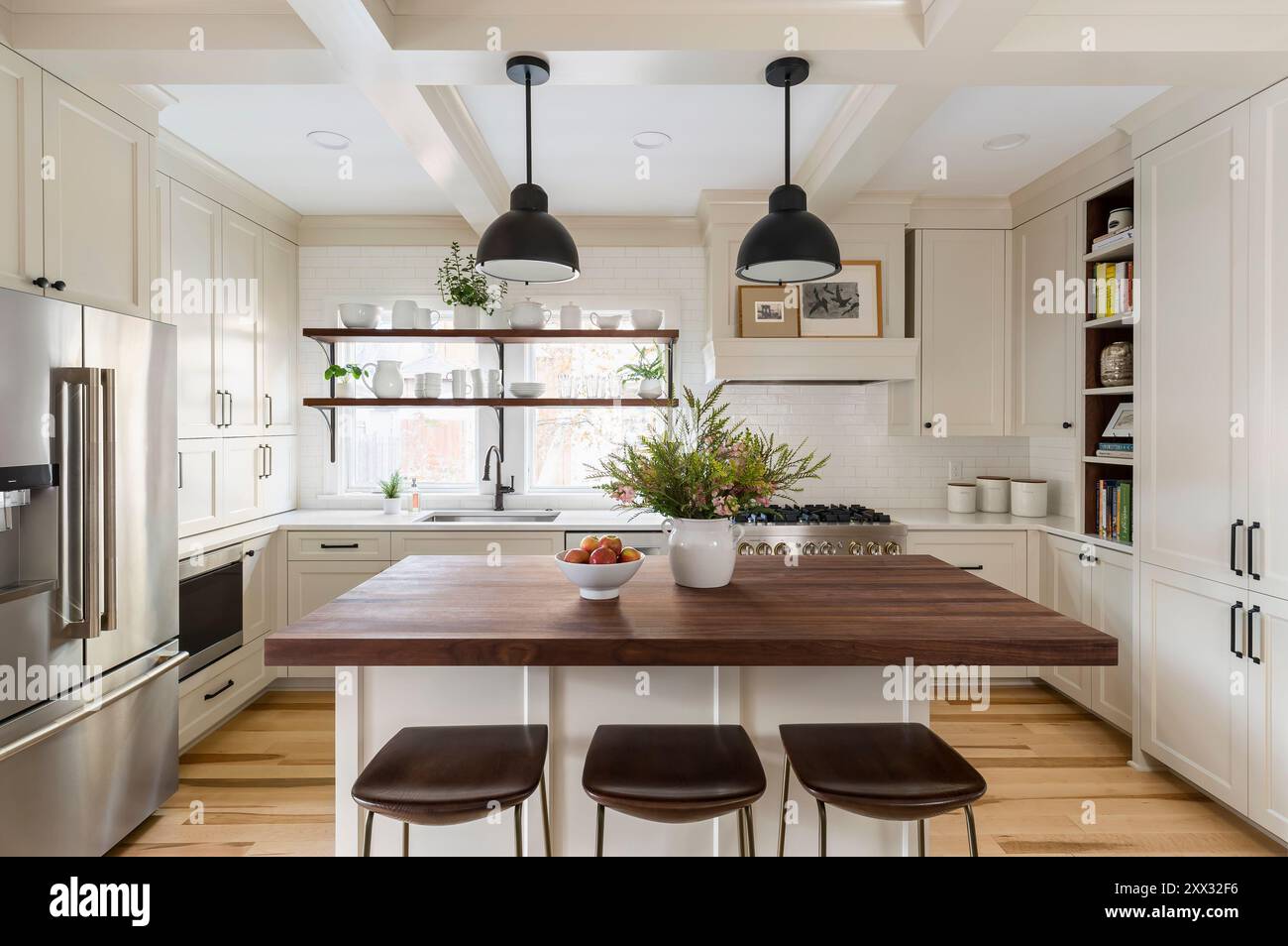 Kitchen with cream colored cabinets and walnut countertop and open ...