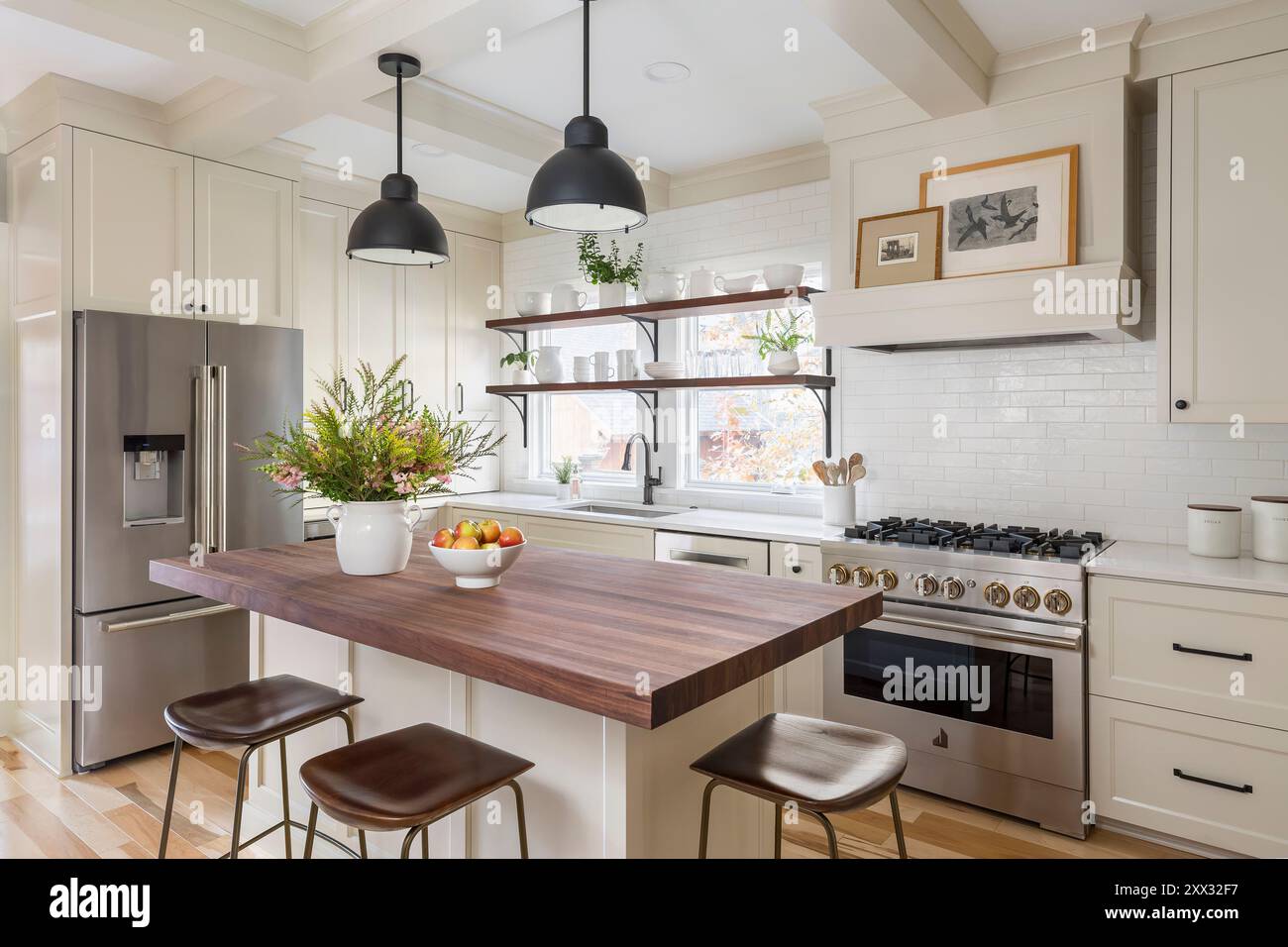 Kitchen with cream colored cabinets and walnut countertop and open ...
