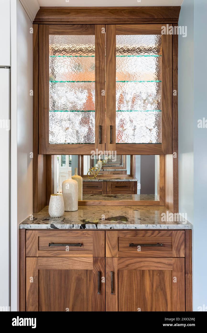 Bar cabinet in kitchen with textured glass on upper cabinets Stock ...