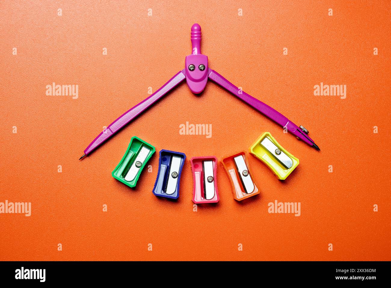 A set of colored pencils and a ruler are arranged in a rainbow pattern ...