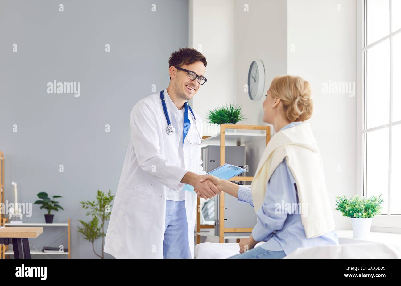 Happy Doctor Or Nurse Shaking Hands With Patient In Hospital Office ...
