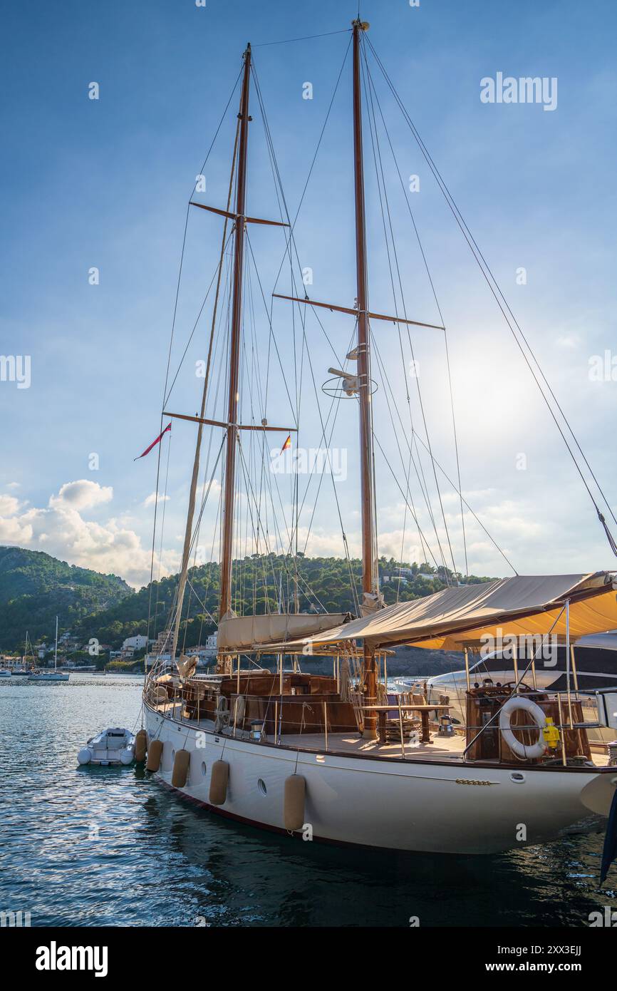 White yacht, sailboat with its sails down, moored in seaport in summer. Vacation on ship ...