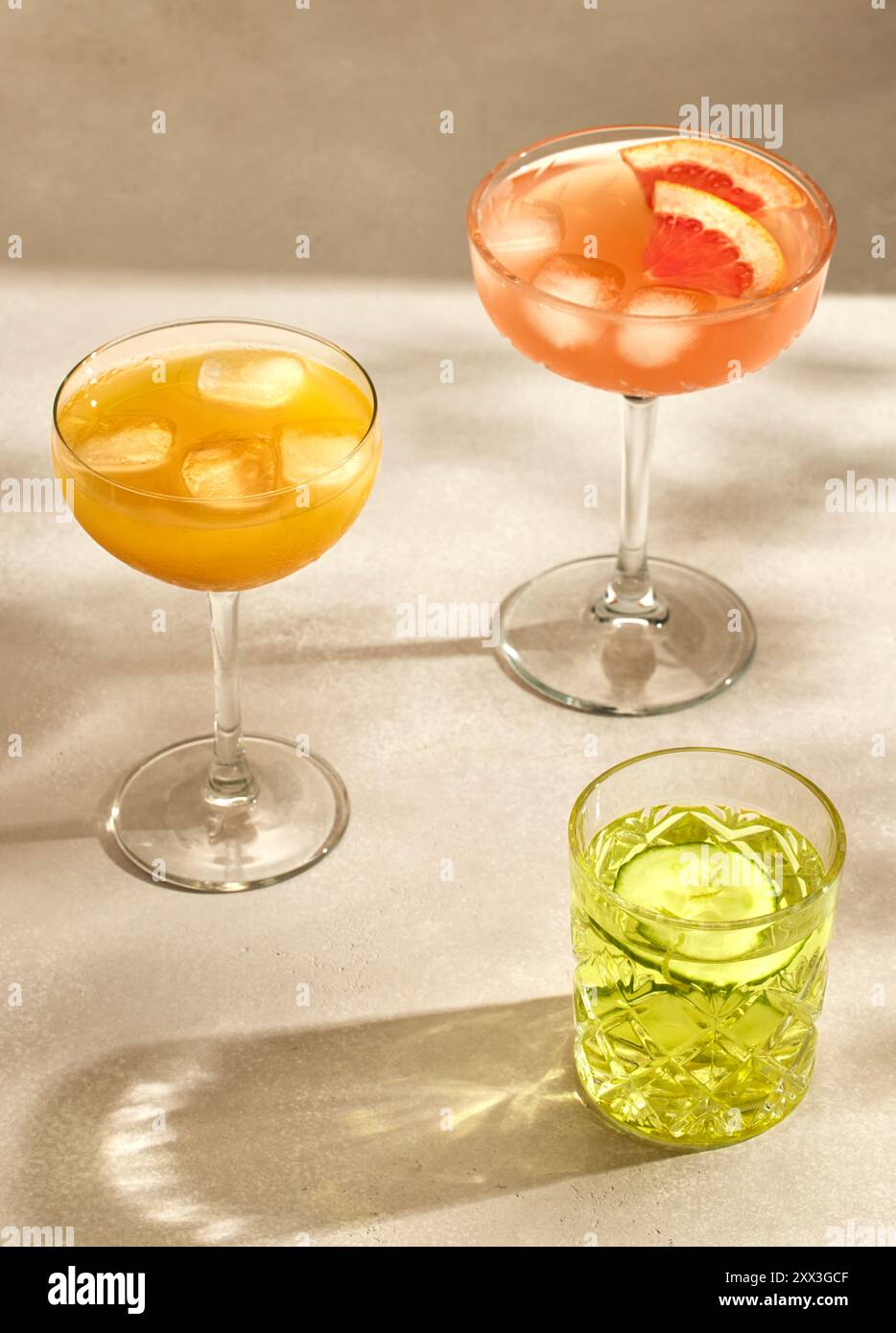 various cocktail glasses on beige sunny table background Stock Photo ...