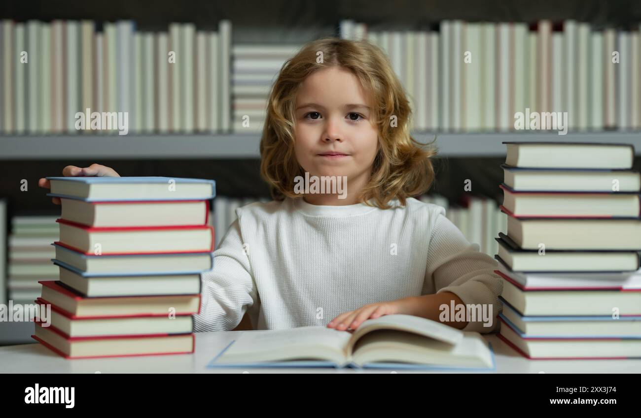 Knowledge day. School boy doing homework on desk in school library ...