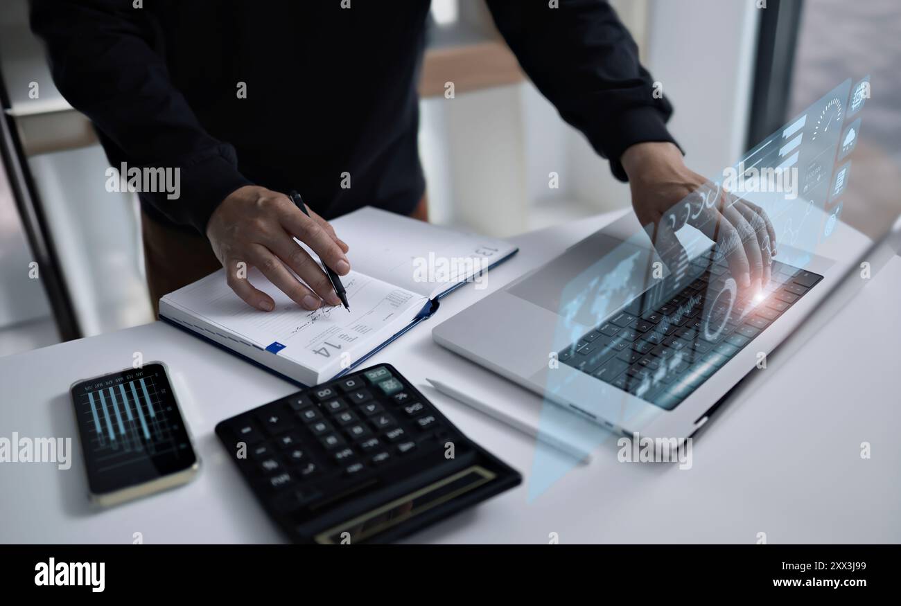 A businessman meticulously plans and analyzes financial data using a ...