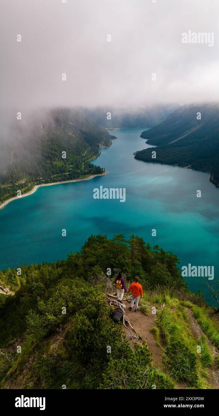 A tranquil afternoon view of Plansee Lake reveals crystal-clear waters ...
