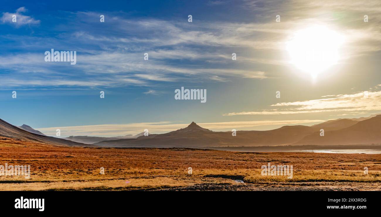 A large mountain range is visible in the distance, with a clear blue ...
