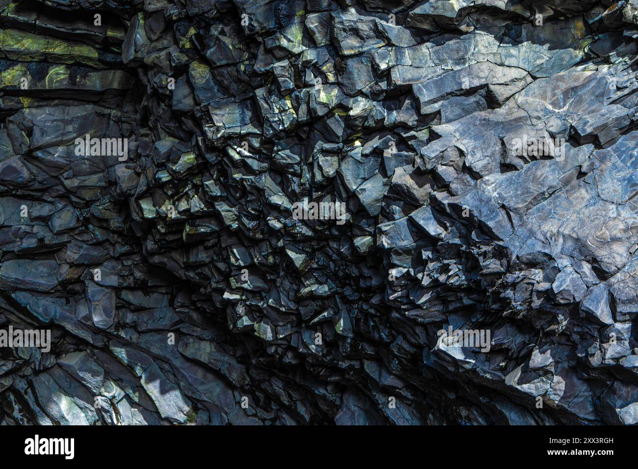 The image is of a rock formation with a dark blue color. The rocks are ...