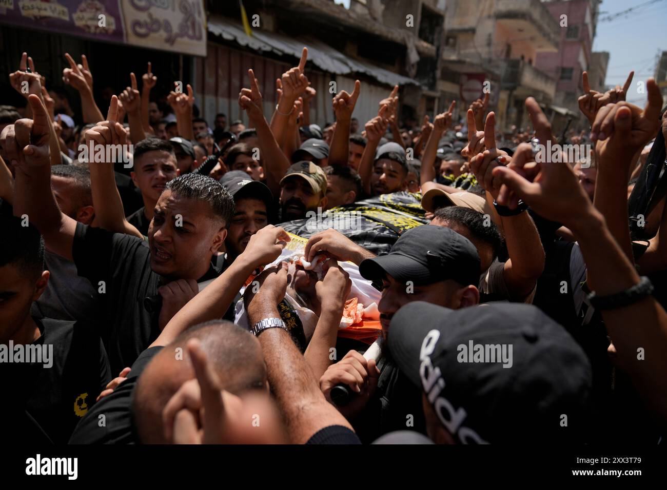 Mourners carry the body of Palestinian Jamal Saudi, 21, wrapped with an ...