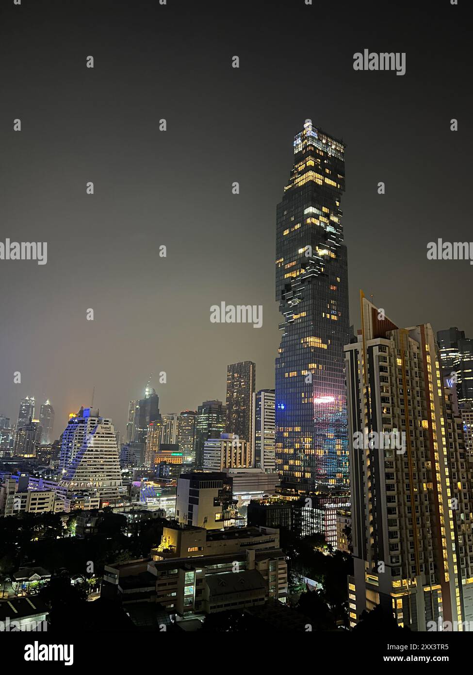 This photo captures the Bangkok skyline at night, featuring the iconic ...