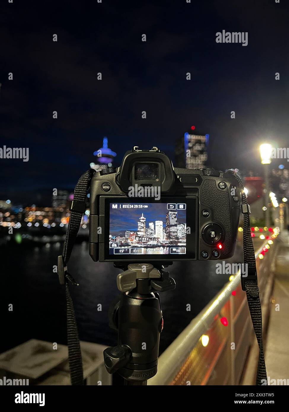A camera on a tripod captures a night view of Vancouver’s skyline, with ...