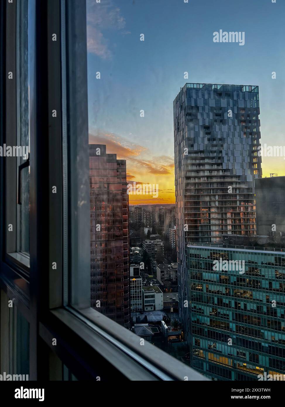 This photo captures a sunset over Vancouver's skyline, seen through a ...