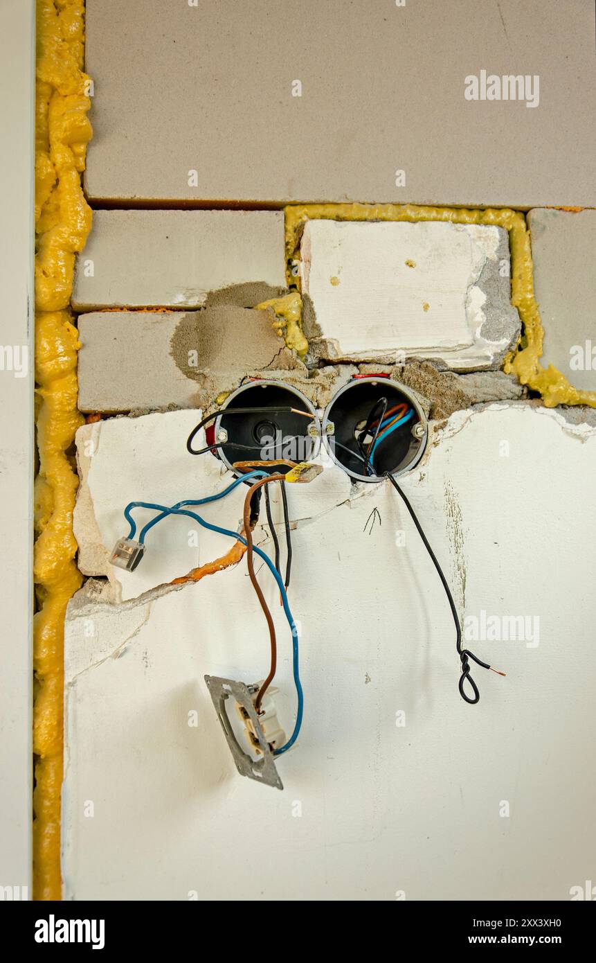 Two future sockets with power wires coming out in a wall under ...