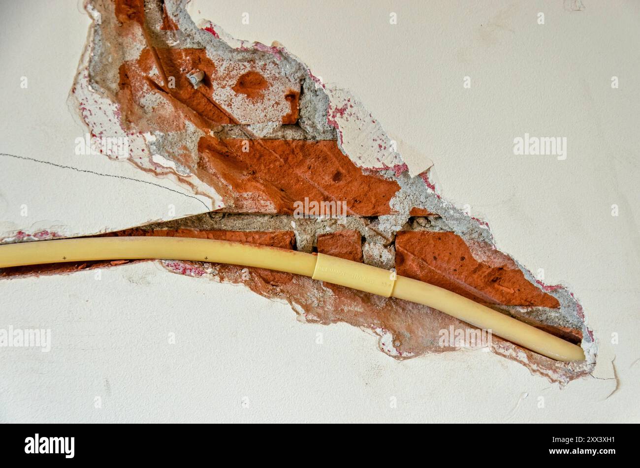 PVC tube in a brick wall with plaster covering during a home renovation ...