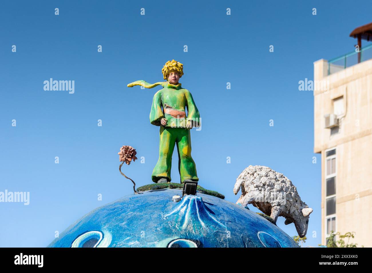 Statue of The Little Prince with his rose and sheep on a blue planet at ...