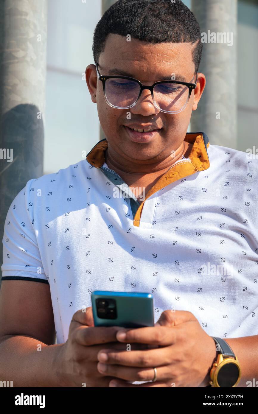 Glamorous smiling black man, sitting using a social media app on a ...
