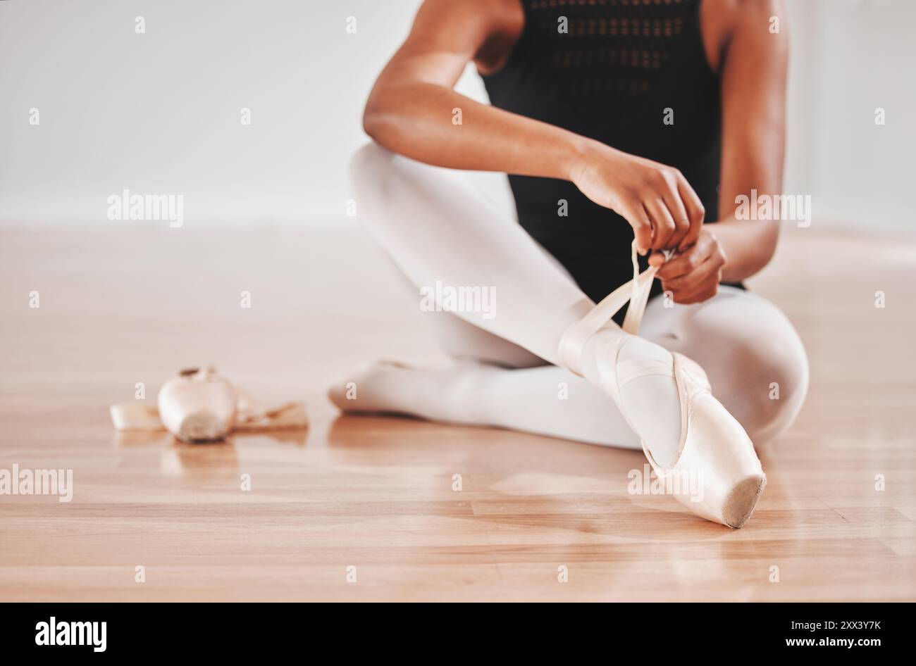 Ballet, person and tying of shoes on floor for practice, adjustment and preparing for dance ...