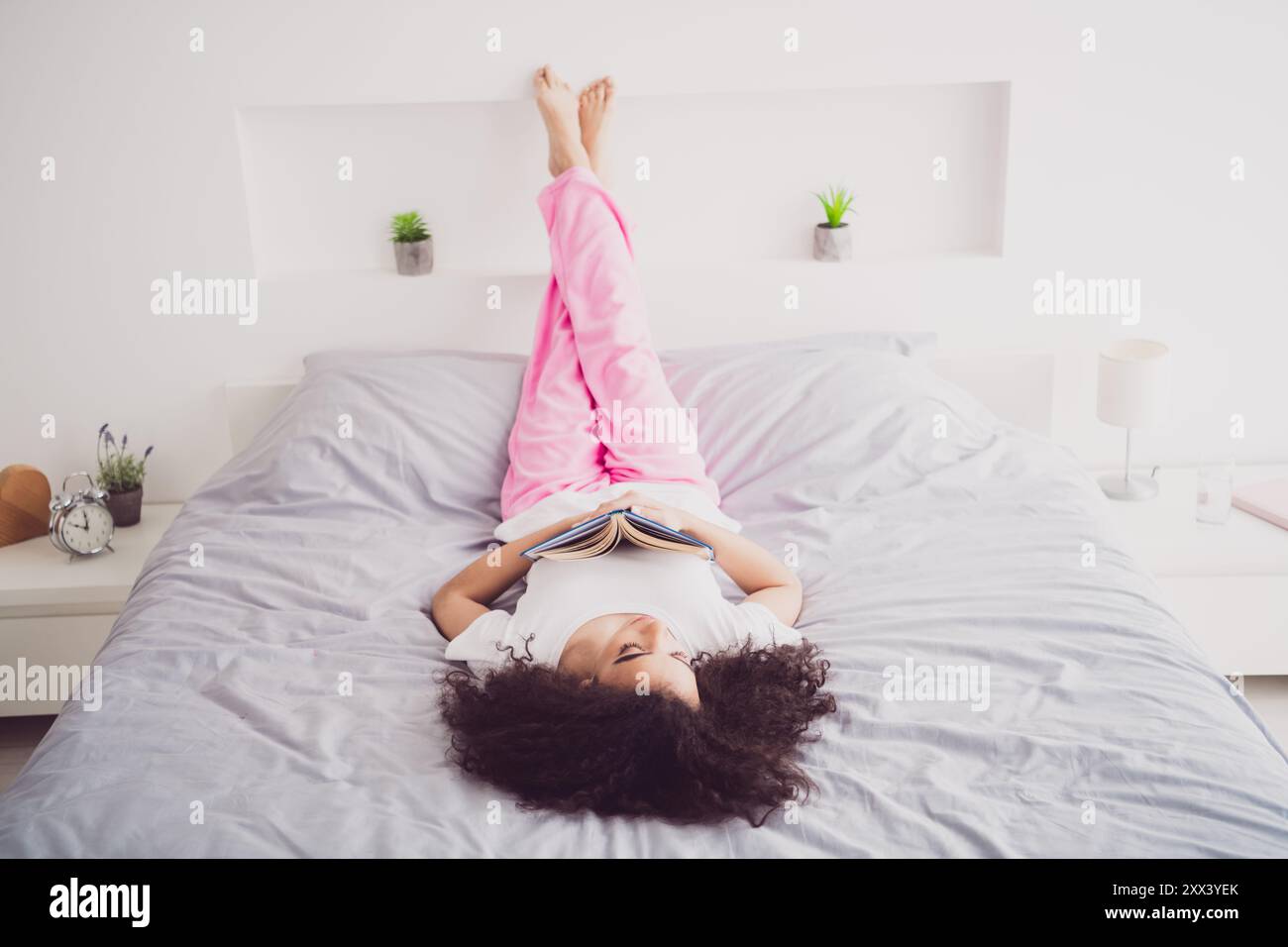 Full length photo of charming young woman lying bed read book sleep ...