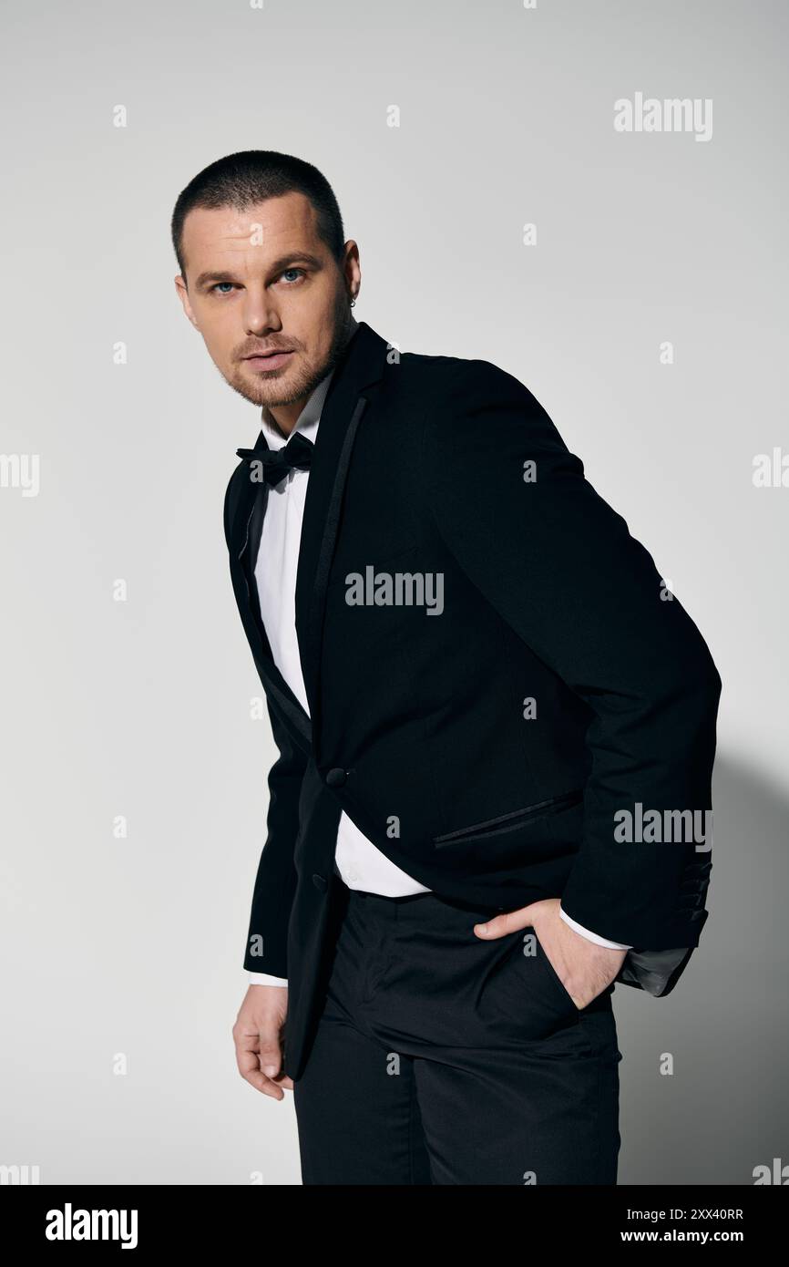 Man in black velvet suit, white shirt, black bow tie, stands ...