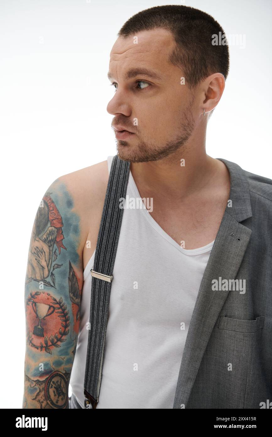 A stylish man with suspenders and a jacket draped over his shoulder ...