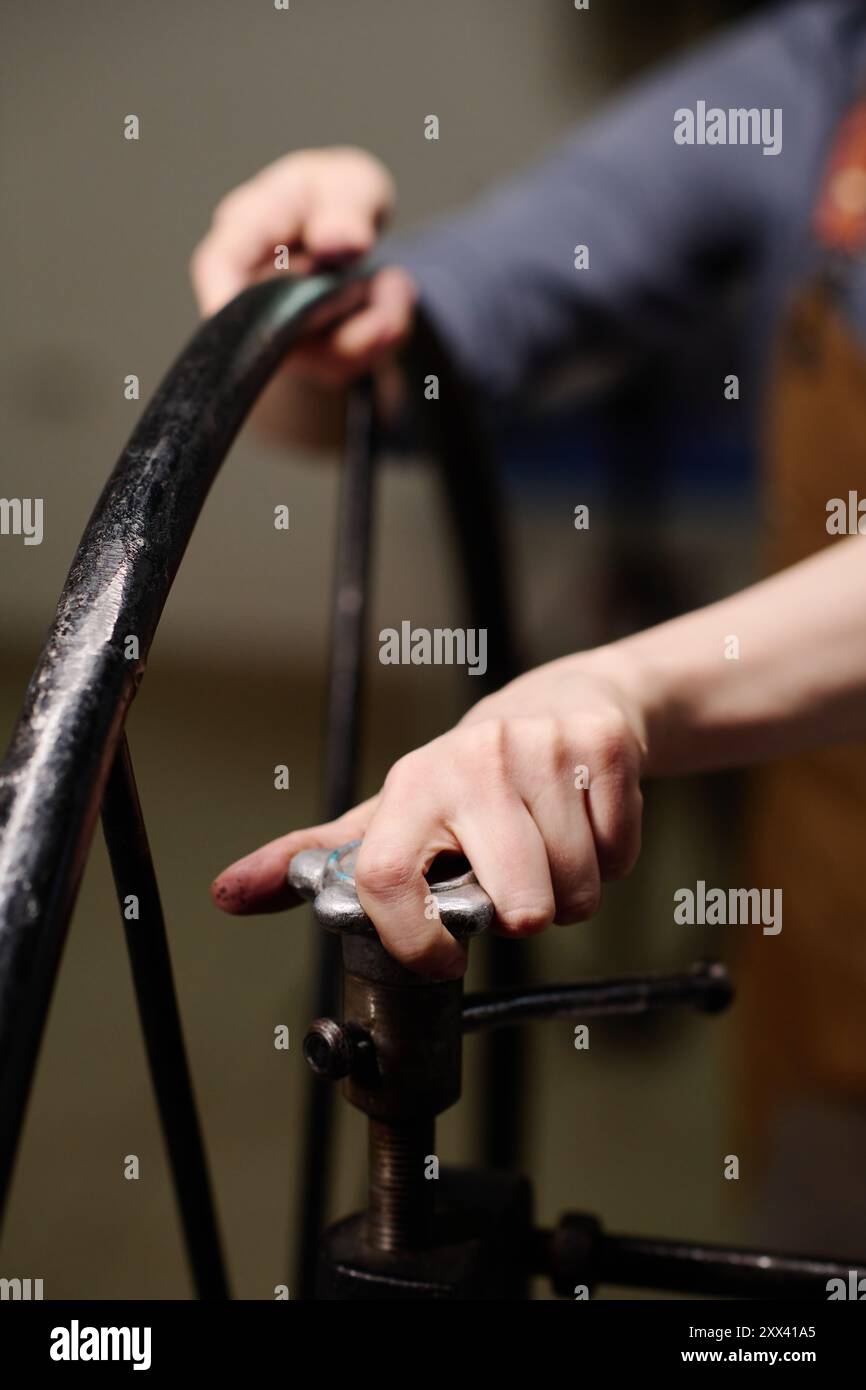 Hand of young female worker of typography turning metallic valve of ...