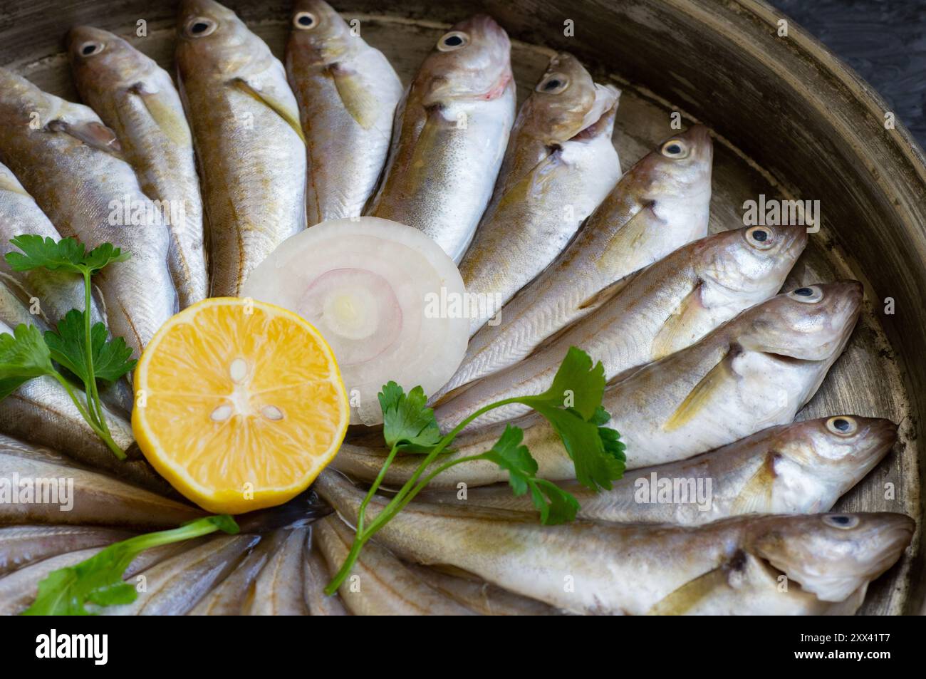 Fresh uncooked haddock fishes on rustic background, raw whiting fish ...