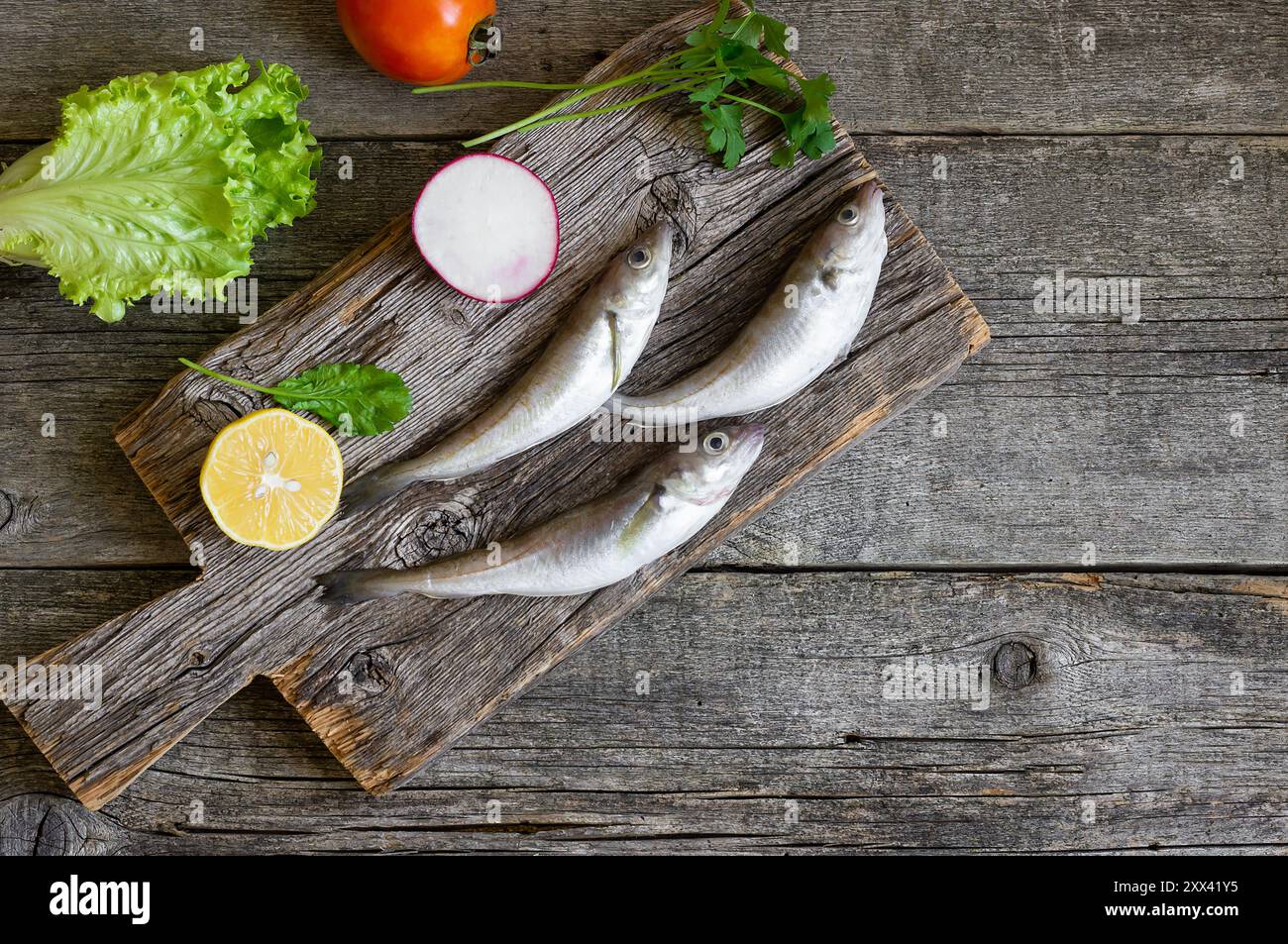 Fresh uncooked haddock fishes on rustic background, raw whiting fish ...