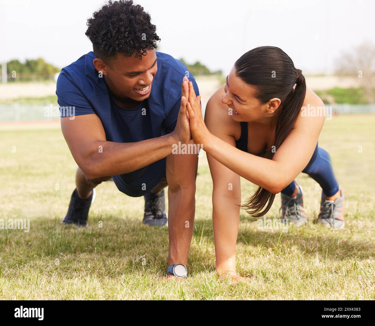 Happy people, push ups and high five with partner on grass field for ...