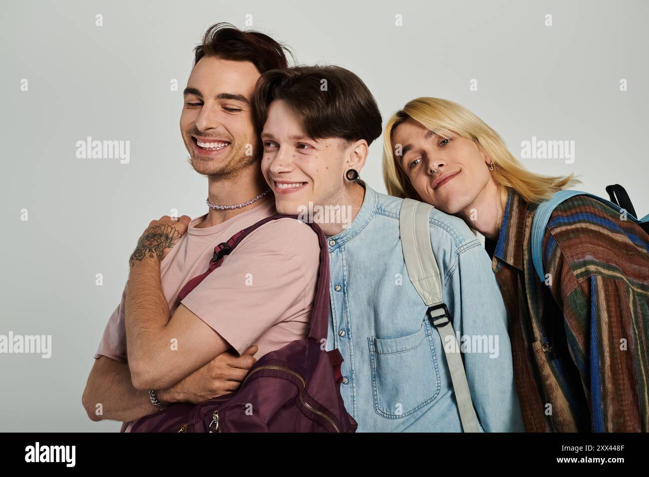 Three young students, part of the queer community, stand together in ...