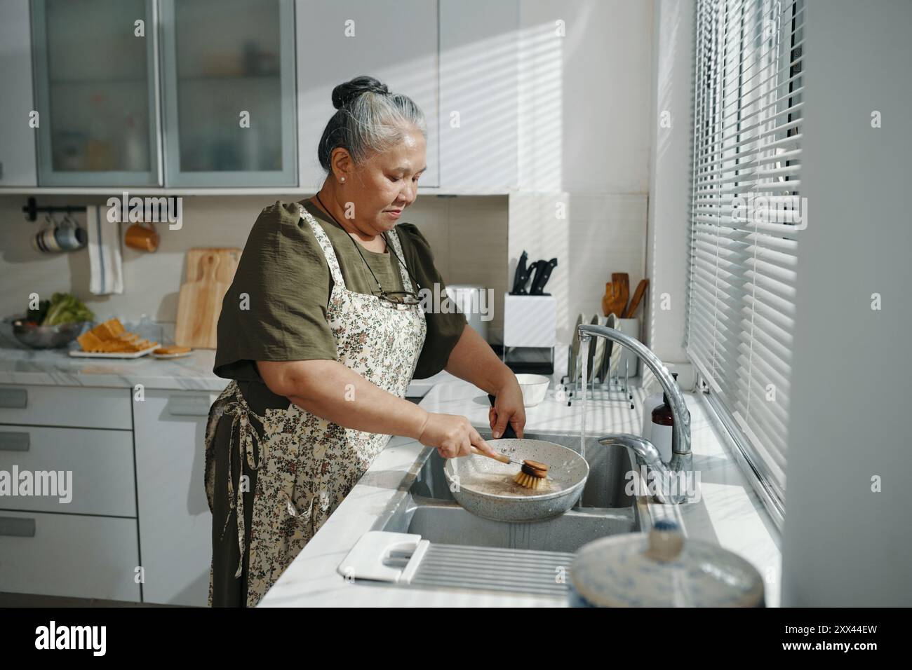 Senior Woman Washing Dishes In The Kitchen Stock Photo - Alamy
