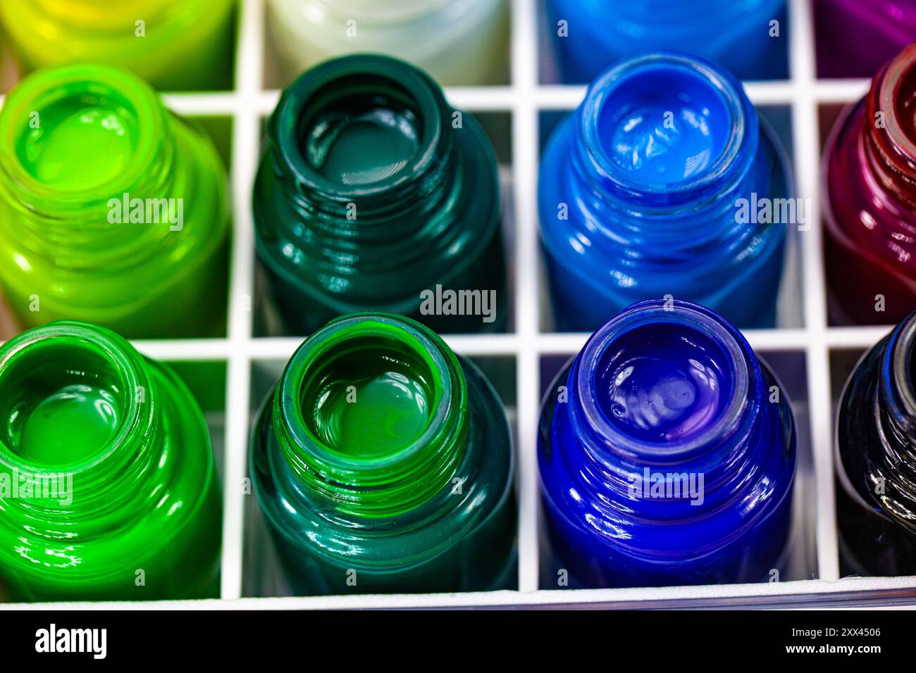 A vibrant display of various colored ink bottles arranged in a grid ...