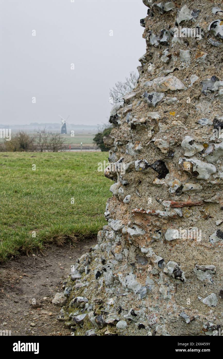 Stone wall of the Roman fort at Burgh Castle, Norfolk, with Berney Arms ...