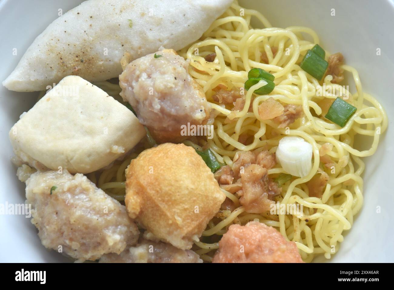 dry Chinese yellow egg noodles topping steamed Hakka meatball made from ...