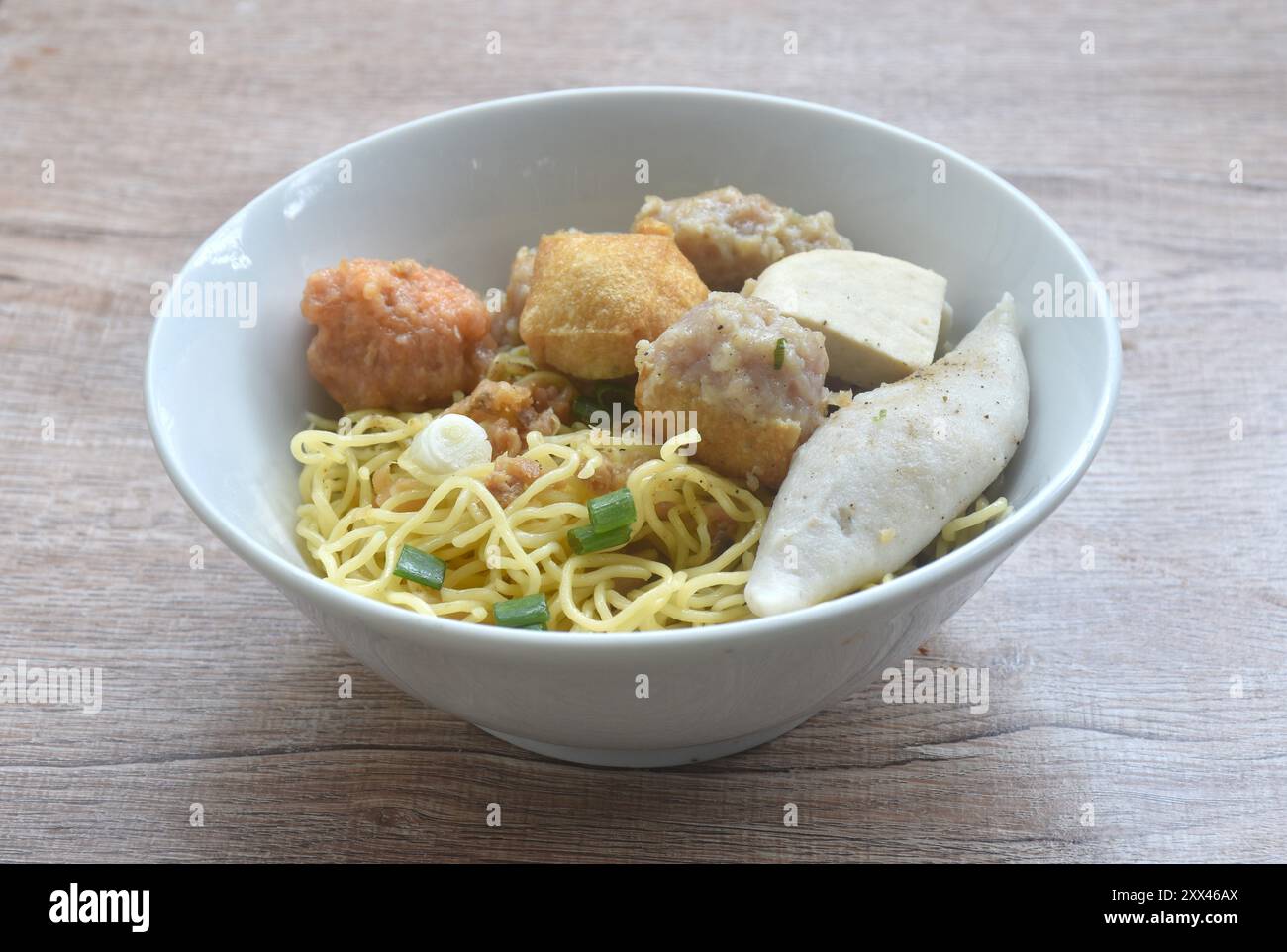 dry Chinese yellow egg noodles topping steamed Hakka meatball made from ...